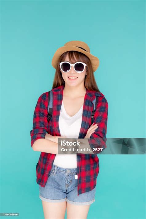 아름다운 초상화 젊은 아시아 여성은 선글라스와 모자 미소를 착용 자신 여름 휴가 고립 된 파란색 배경 모델 소녀 패션 배낭 여행 개념을 즐길 수 있습니다 가방에 대한 스톡