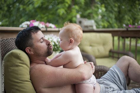 Shirtless Father Playing With Son While Relaxing On Porch Stock Photo Adobe Stock