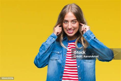 시끄러운 음악의 소음에 대 한 짜증이 식이 손가락으로 귀를 덮고 격리 된 배경 위에 아름 다운 젊은 금발 여자 청각 장애인 개념입니다 가리기에 대한 스톡 사진 및 기타