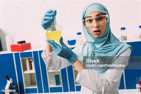 충격을 받은 여성 무슬림 과학자가 화학 실험실에서 실험 중 카메라를 보고 플라스크를 들고 있는 모습 Stem 주제에 대한 스톡 사진 및 기타 이미지 Istock