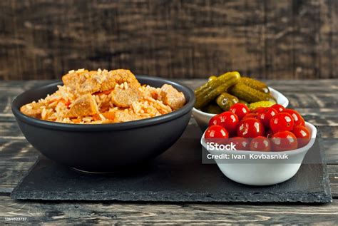 검은 그릇에 고기와 당근을 곁들인 필라프 검은 색 배경에 양념 버섯 토마토와 오이 초라한 테이블에 음식 오래된 나무 판에 그릇 고기에 대한 스톡 사진 및 기타 이미지