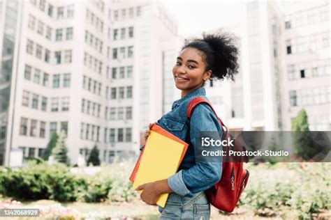 행복한 아프리카 계 미국인 대학 소녀 들고 책 포즈 근처 대학 서 있기에 대한 스톡 사진 및 기타 이미지 서 있기 십대 소녀 캠퍼스 Istock