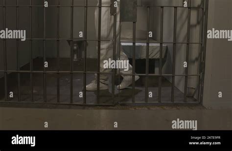 Modern Prison Or Jail Scene Pacing Behind Bars Male Inmate Stock