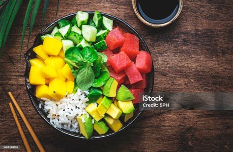 신선한 참치 아보카도 망고 오이 양상추 흰 쌀을 곁들인 포케 볼 간장 라임 참깨 드레싱 오래 된 소박한 나무 테이블 배경 평면도 0명에 대한 스톡 사진 및 기타 이미지