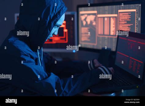 Girl Hacker In A Hood Typing Program Code While Committing A Cybercrime Hacking A System