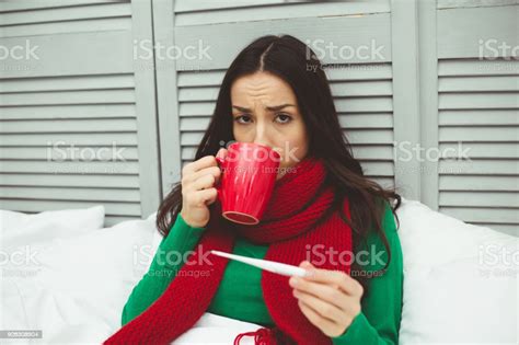 매우 높은 몸 온도입니다 빨간 스카프에 젊은 아픈 여자는 온도계로 온도 측정합니다 건강과 질병의 개념입니다 가정의 방에 대한 스톡 사진 및 기타 이미지 Istock