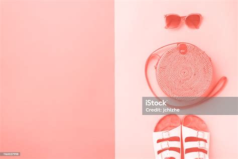 세련된 등나무 가방 코코넛 자작 나무 야자수 가지 산호 색상 배경에 선글라스 복사 공간이 있는 맨 위 뷰입니다 트렌디 한 대나무