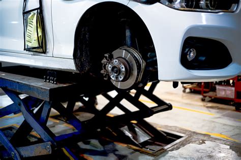 자동차 수리 차고에서 타이어를 교체하기 위해 유압식 자동차 잭 리프트로 들어 올리는 자동차 0명에 대한 스톡 사진 및 기타