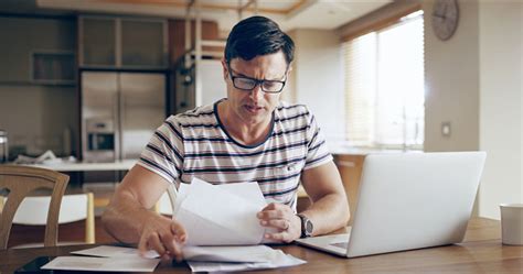 남자 스트레스 및 대출 서류 작업은 작업 지불 및 금융 부채와 함께 집에서 노트북으로 이루어집니다 모기지 불안 및 청구서 확인 인플레이션 및 비용 계획을 통한 투자 및