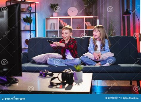 Hermano Pequeño Y Hermana Sentados En El Sofá Viendo La Televisión