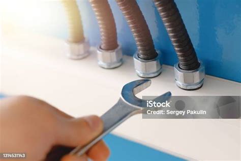 골판지 단열재의 전원 케이블과 파란색 벽에 렌치가 밀착된 바위 전기 기사입니다 건설 산업에 대한 스톡 사진 및 기타 이미지 건설 산업 검은색 고정시킴 Istock