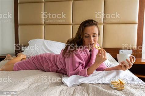매력적인 젊은 백인 여자 혼자 홈 아파트에서 말린 과일과 사과의 그녀의 아침 식사를 먹는 동안 녹차 한 잔을 들고 가정 생활에 대한 스톡 사진 및 기타 이미지 Istock