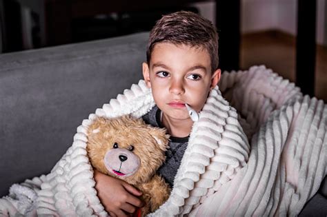 질병 계절 바이러스 문제 개념 아이는 온도계의 온도를보고 소파에 누워 독감이 아픈 고열로 침대에 누워있는 아픈 소년 감기 독감과 편두통 가정 생활에 대한 스톡 사진 및 기타