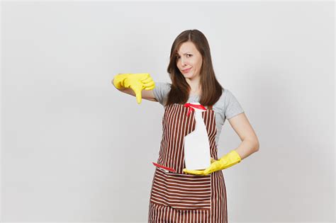 노란 장갑에 젊은 슬픈 화가 피곤된 주부 줄무늬 앞치마 흰색 배경에 고립 된 포켓에서 걸 레 롤러를 청소 여자 청소기 액체 보유