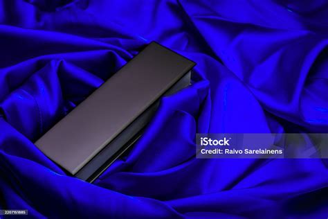 고급스러운 딥 블루 새틴 패브릭에 우아한 주름이 있는 세련된 검은색 직사각형 상자로 프리미엄 제품 디스플레이 브랜딩 또는 포장 디자인에 이상적입니다 0명에 대한 스톡 사진