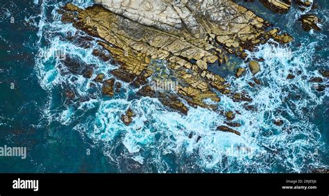 Aerial Downward View Of Waves Crashing Against Partially Submerged