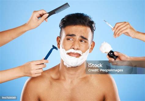파란색 배경에 스튜디오에서 면도하거나 머리를 빗기 위한 장비를 들고 손으로 얼굴 면도 및 몸단장 아름다움을 위해 이발사에서