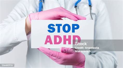흰색 코트와 분홍색 멸균 장갑에 젊은 여성 의사의 자른 보기 텍스트 Stop Adhd와 카드를 들고 의료 개념 학습에 대한 스톡