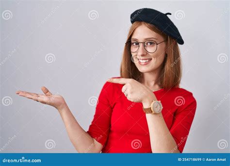 Young Redhead Woman Standing Wearing Glasses And Beret Amazed And