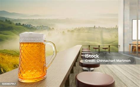 나무 테이블과 의자 세트에 넣어 상단에 맥주 거품이있는 투명 유리에 초안 또는 공예 맥주 신의 빛이나 햇빛이 있는 나무 테라스의 라운지 좌석3d 렌더링 0명에 대한 스톡