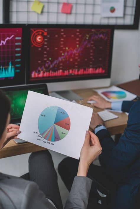 View Of Information Security Analyst Holding Paper With Chart Near Colleague Using Computer At