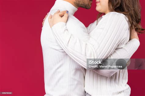 빨간 배경을 껴안고 흰색 스웨터를 입은 부부의 확대 된 사진 발렌타인 데이에 모든 연인의 개념 긍정적인 감정 표현에 대한 스톡 사진 및 기타 이미지 Istock