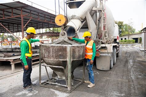 토목 기사와 함께 현장에서 일하는 메이슨 건설 노동자 믹서 콘크리트 트럭에서 곰팡이에 콘크리트를 붓는 아시아 건축업자 조립식