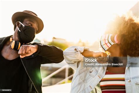 팔꿈치를 부딪치는 새로운 사회적 거리 인사를하는 얼굴 보호 마스크를 착용한 아프리카 계 미국인 친구 청소년 밀레니엄 세대 와 코로나 바이러스 확산을 피하기 위한 건강 관리