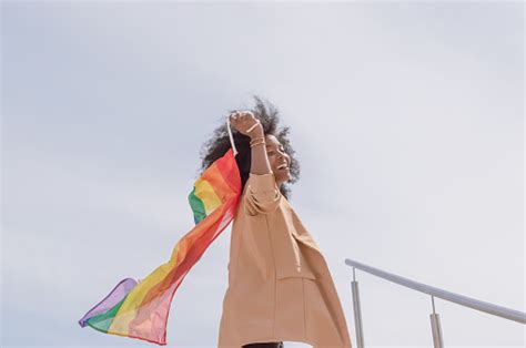 젊은 갈색 머리 라티나 소녀 와 Afro 미소 와 댄스 만족 미소 A 게이 자부심 플래그 Gay Pride Parade에 대한 스톡 사진 및 기타 이미지 Gay