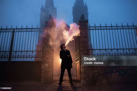 남자는 오래 된 건물에 대 한 전자 담배를 연기 안개와 증기와 신비한 사진 건강관리와 의술에 대한 스톡 사진 및 기타 이미지 건강관리와 의술 검은색 검정색 배경