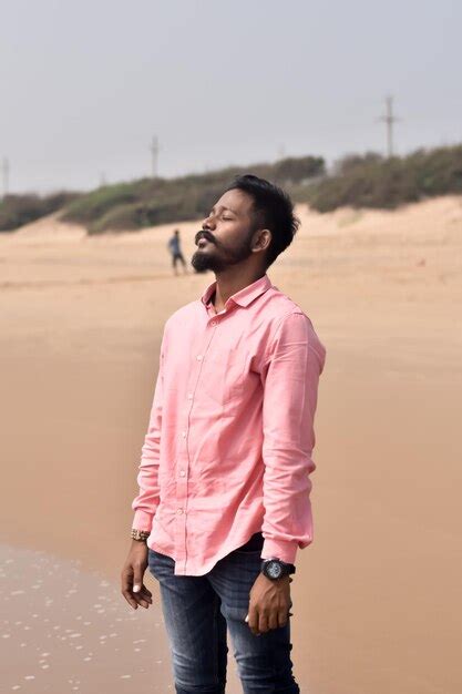 Premium Photo Young Man Standing At Beach Against Sky