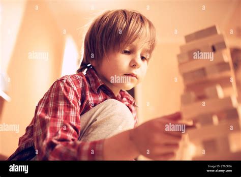 Preschool Cute Boy Playing In A Table Game With Wooden Blocks At Home