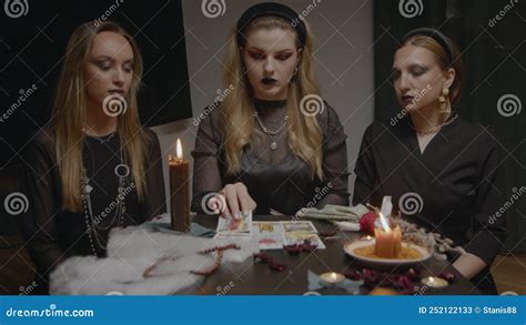 Two Female Witches Hold Pumpkins In Their Hands Covering Their Faces