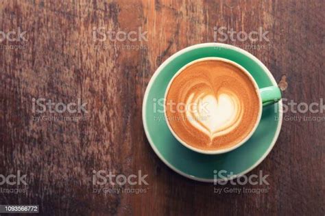 나무 테이블 배경에 녹색 컵 라 떼 아트와 접시에에서 뜨거운 카푸치노 커피의 최고 보기 커피 마실 것에 대한 스톡 사진 및 기타 이미지 커피 마실 것 하트 모양 녹색