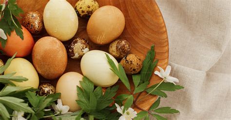 행복한 부활절 소박한 린넨 천에 봄 꽃이 있는 나무 그릇에 담긴 현대 부활절 달걀 텍스트를 위한 공간이 있는 평면도 피는 꽃 말미잘과 회색 직물에 자연 염색 계란