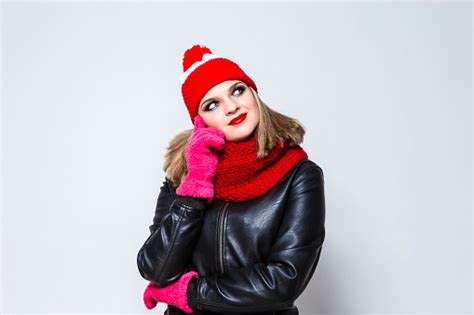 따뜻한 모자와 스카프를 입은 고요한 백인 여성 금발 소녀의 초상화가 꿈꾸는 표정으로 포즈를 취하고 있습니다 25 29세에 대한
