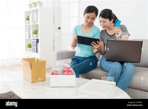 Beautiful Young Sisters Looking At Mobile Pad Computer Choosing Online Shopping Goods And Using
