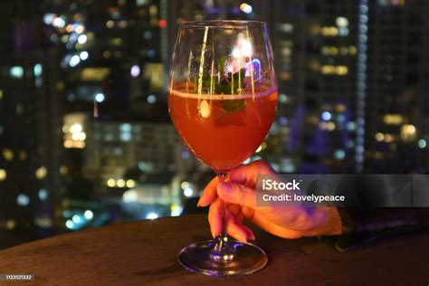 루프 탑 바에서 레드 칵테일 한 잔을 들고 있는 여성의 손은 도시의 야경을 한눈에 볼 수가 있습니다 레스토랑에 대한 스톡 사진 및 기타 이미지 Istock