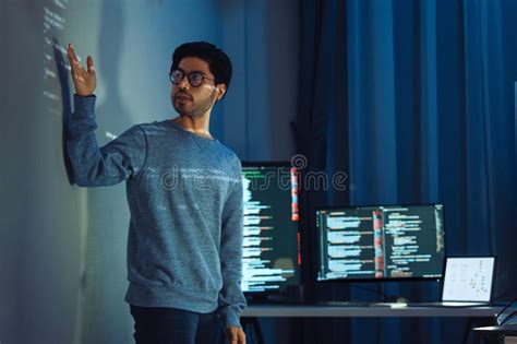 Indian Man Programmer Standing In Front Of A Screen With Code Projected Presentation The