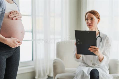 Pregnant Woman Hands Touching Big Belly In Doctor Office Female Doctor