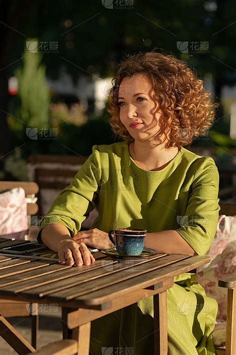 一个美丽的女人坐在夏日的咖啡馆里喝咖啡素材 花瓣网