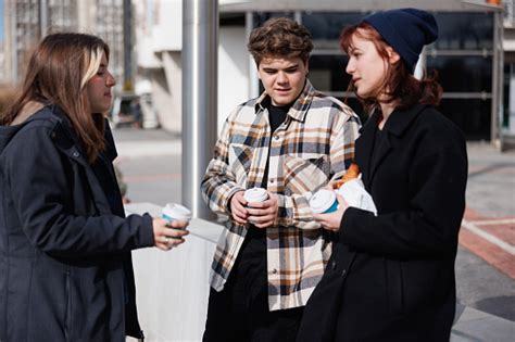 야외에 서 있는 세 명의 십대가 종이컵에 커피를 마시고 간식을 먹으며 14 15 살에 대한 스톡 사진 및 기타 이미지 14