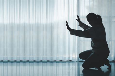 일몰 시간에 현대 교회에서 무릎을 꿇고 기도하는 여자의 실루엣 하느님께 드리는 여성 가톨릭 기도 예배는 믿음으로 새벽에 가정에서 더 나은 삶을 기원합니다 무릎을 꿇고 있는