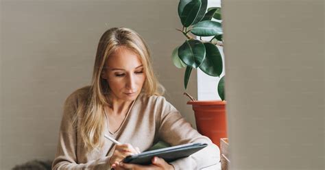 아름 다운 금발 젊은 여성 아티스트 일러스트 레이터 집에서 창 근처 태블릿에 그리기 사진 Unsplash의 앉아 이미지