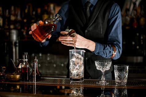 바텐더는 갈색 알코올 음료와 병에서 칵테일의 재료를 측정합니다 바에 대한 스톡 사진 및 기타 이미지 바 바 카운터 바텐더