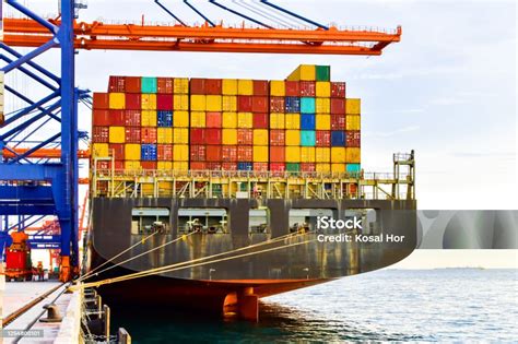 거대한 파나마 크기의 컨테이너 선박은 항구 터미널에서 컨테이너화물을 배출하고 적재합니다 부두 크레인은 트럭에서 선박으로 컨테이너를 픽업합니다 선박에 대한 스톡 사진 및 기타