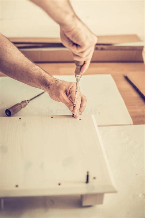 Young Man Assembles Furniture In The New House The Details Laid Around
