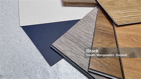 인테리어 재료 샘플 보드의 클로즈업 조합에는 재와 오크 나무 비닐 바닥 타일 파란색과 회색 패브릭 적층 회색 돌 배경에 배치된 엔지니어링 바닥 타일이 포함되어 있습니다 색상