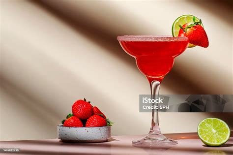 딸기 마가리타 은색 데킬라 라임 주스 리큐어 딸기 및 설탕 테두리가있는 유리에 얼음이 들어간 여름 알코올 칵테일 음료 베이지색 분홍색 바닐라 배경입니다 0명에 대한 스톡