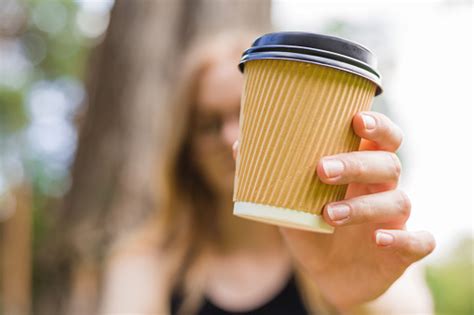 여자는 종이 커피 컵을 들고있다 가져 가거나 배달 개념을 가져 가라 공간을 복사합니다 여름 라이프 스타일 머그잔에 텍스트 나